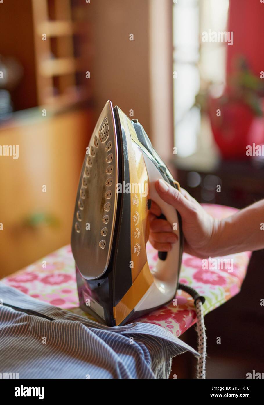 Timer to iron out the wrinkles. an unidentifiable woman ironing a shirt ...