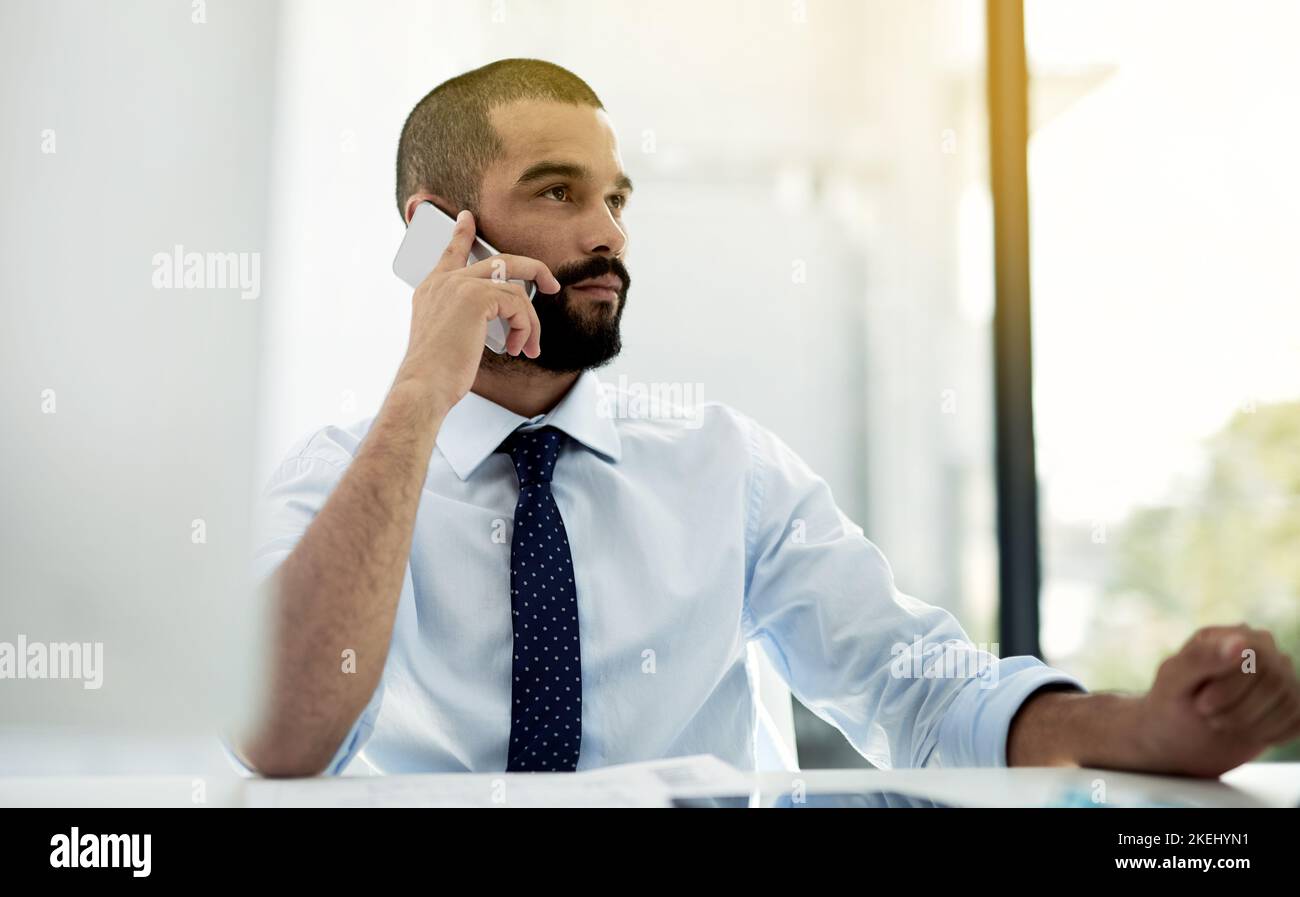 Keeping his clients in the loop. a young businessman talking on the ...