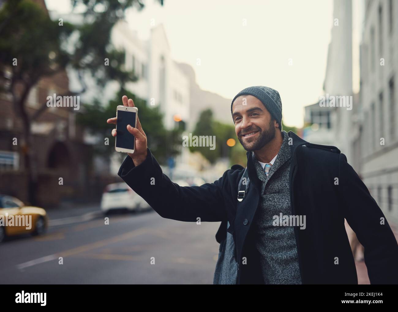 Time to catch a taxi. a fashionable young man waving for a cab Stock ...