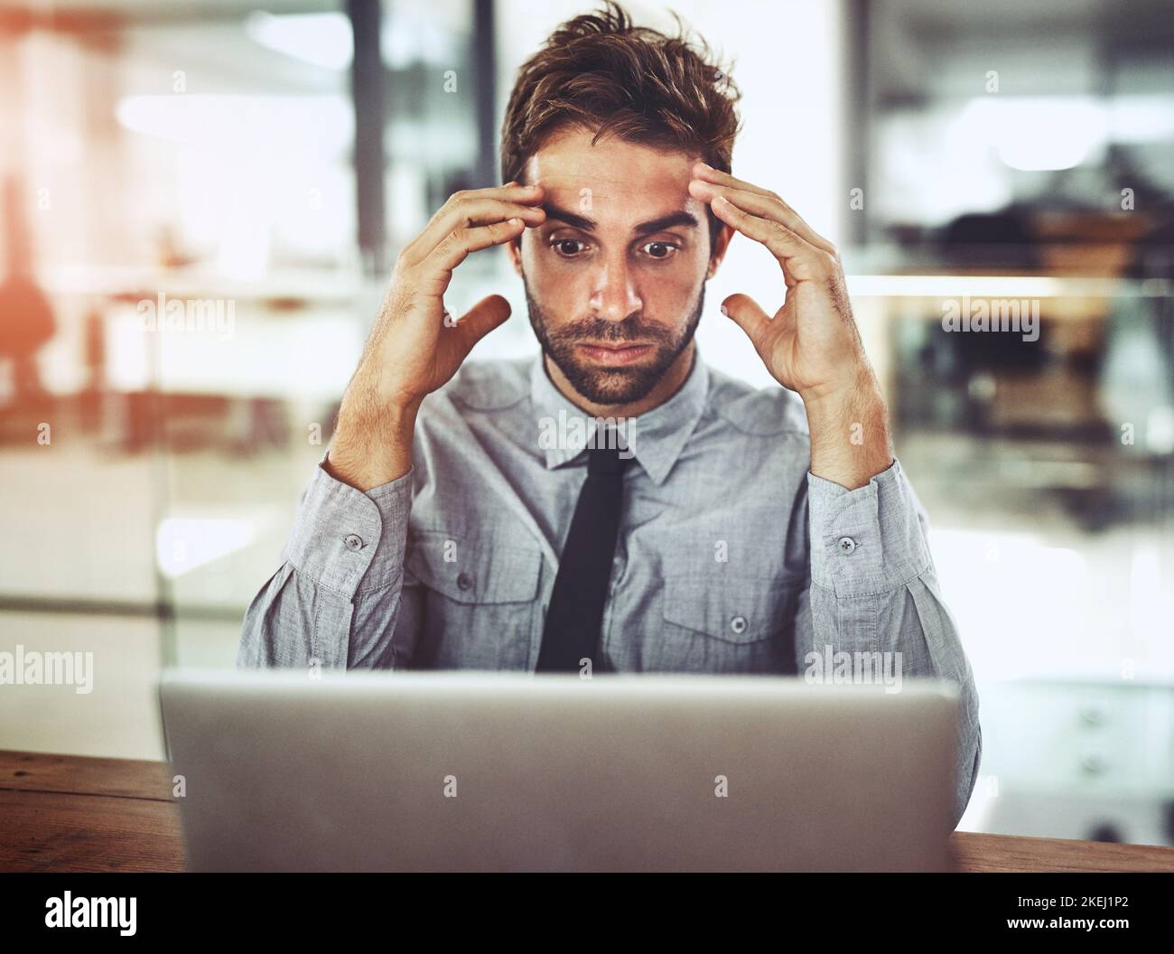 Oh no...a handsome young businessman looking stressed out while working ...