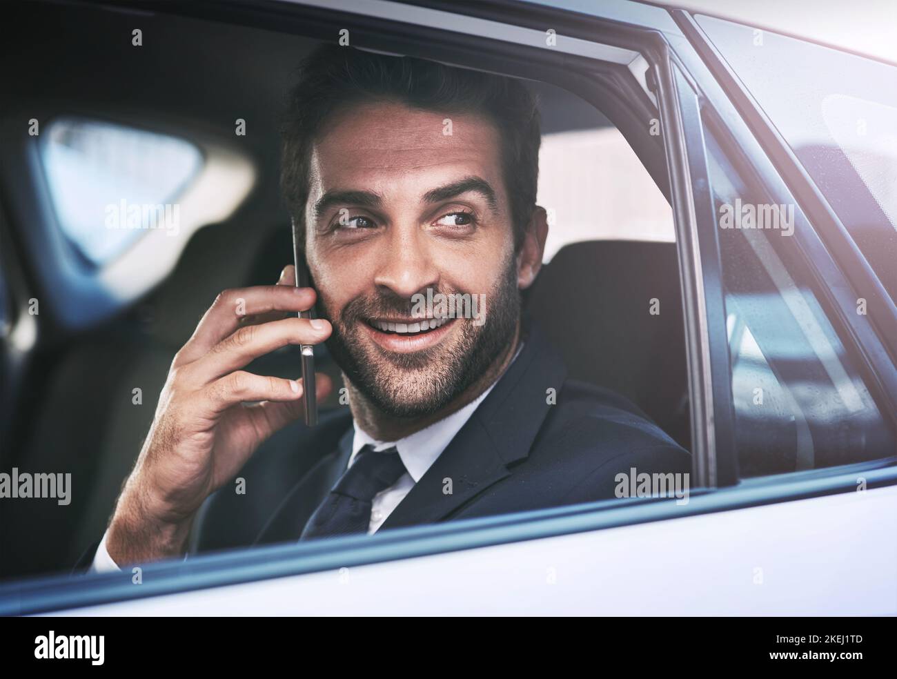 Im just pulling up. a handsome young businessman making a phonecall ...