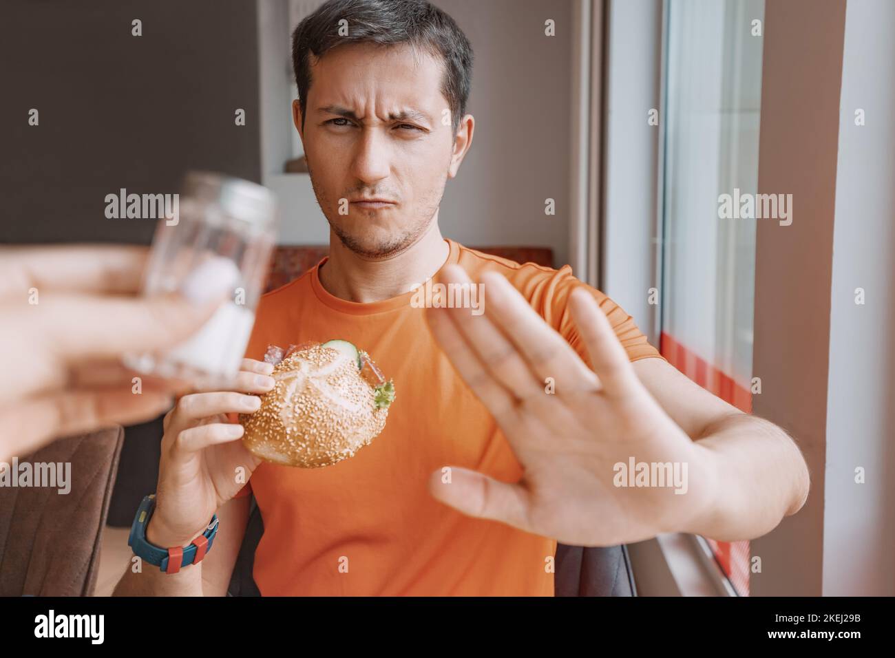 Frowned man refuses salt in the restaurant with a gesture. Healthy ...