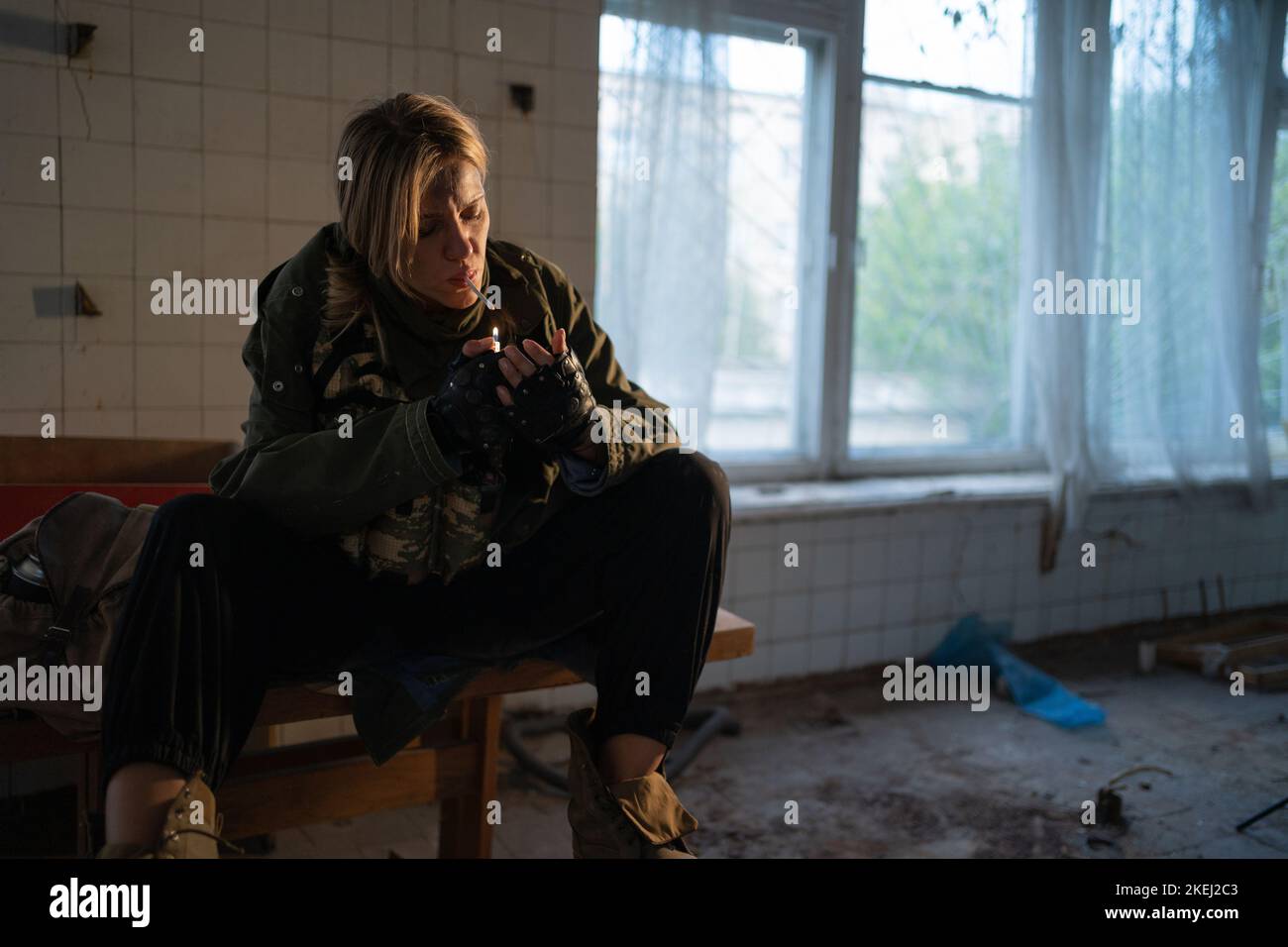 Special female soldier after the fight sitting in ruined building ...