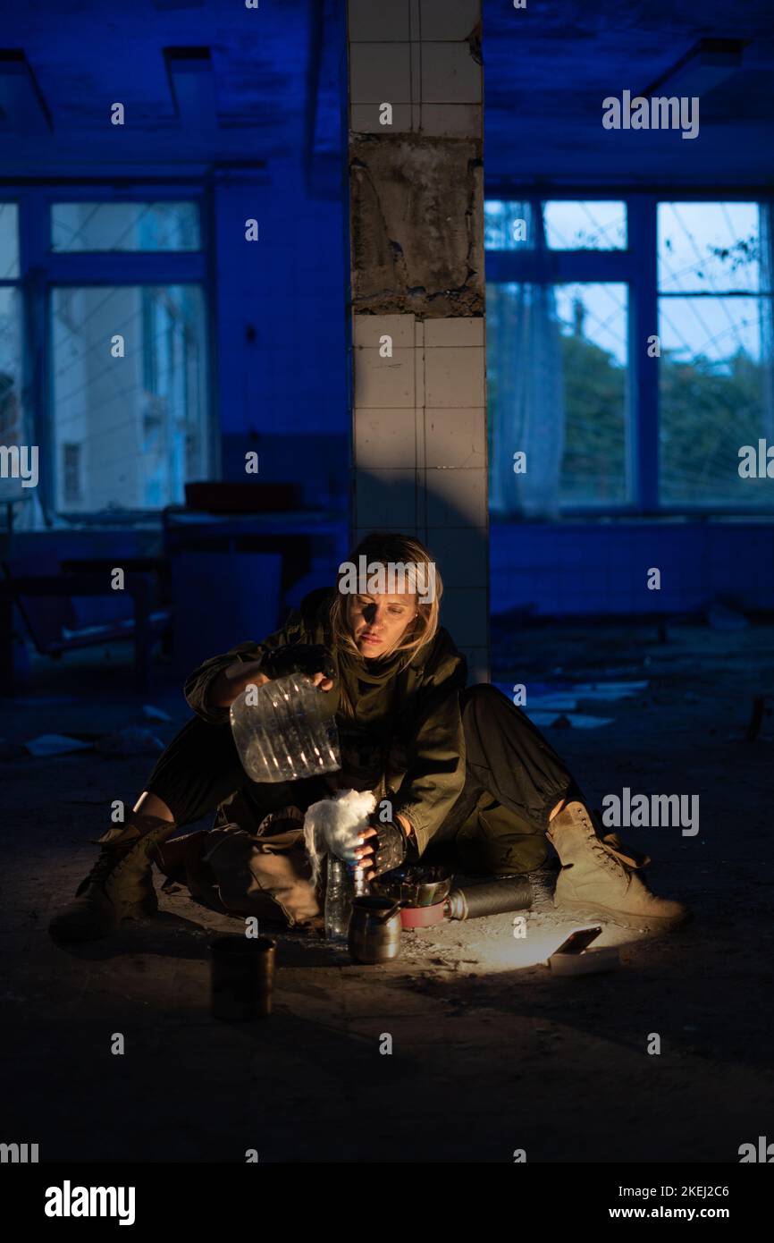Post-apocalypse. a young woman sits on the floor of an abandoned ...
