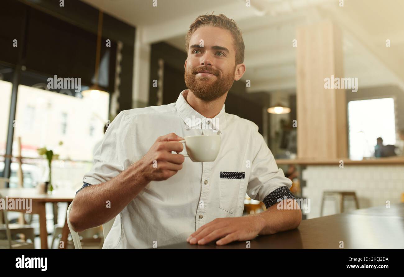Time for a coffee break. a young man sitting at a table in a cafe Stock ...
