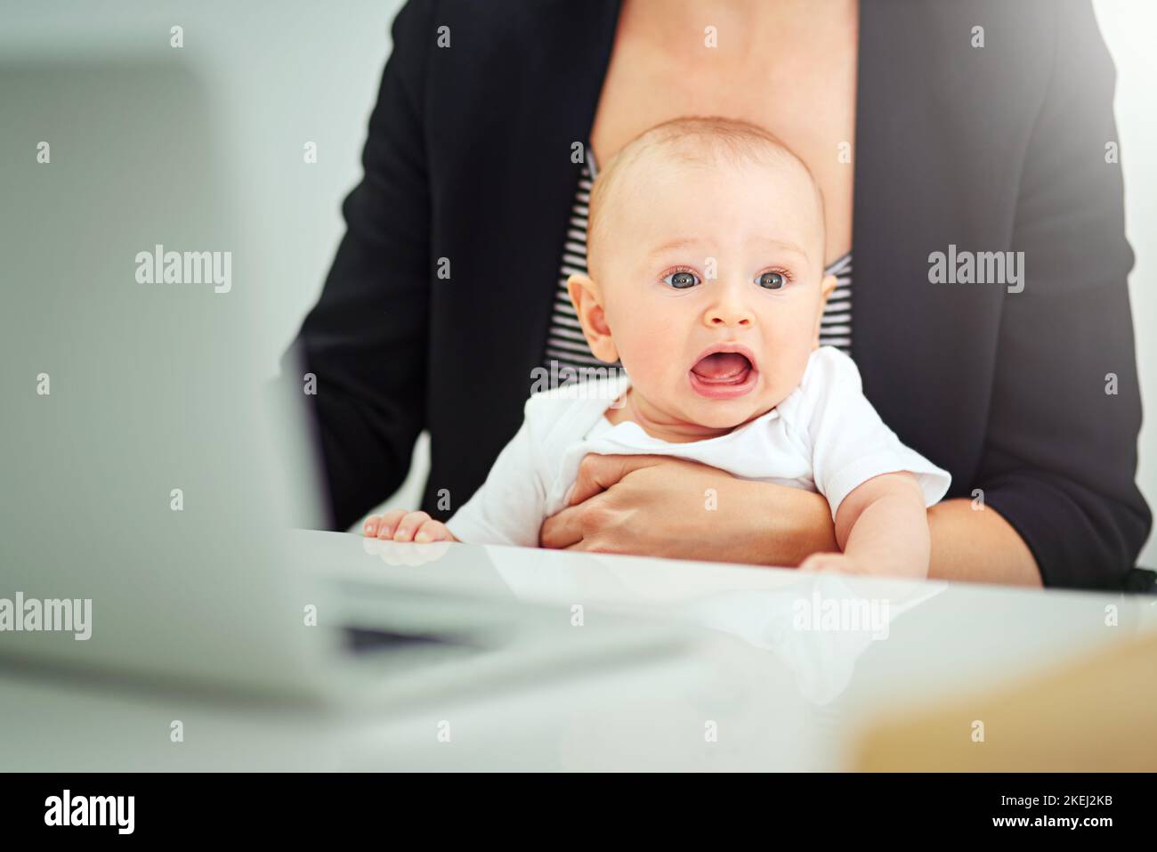 Mom, close the laptop and lets play. a businesswoman looking after her ...