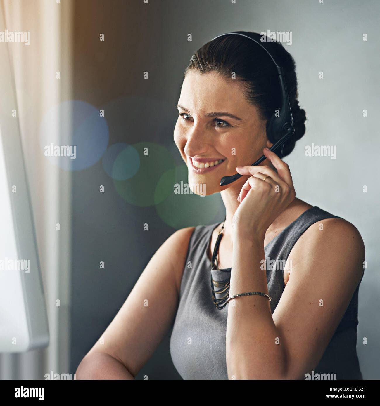 Hello. How may I direct your call. a female receptionist working in her ...