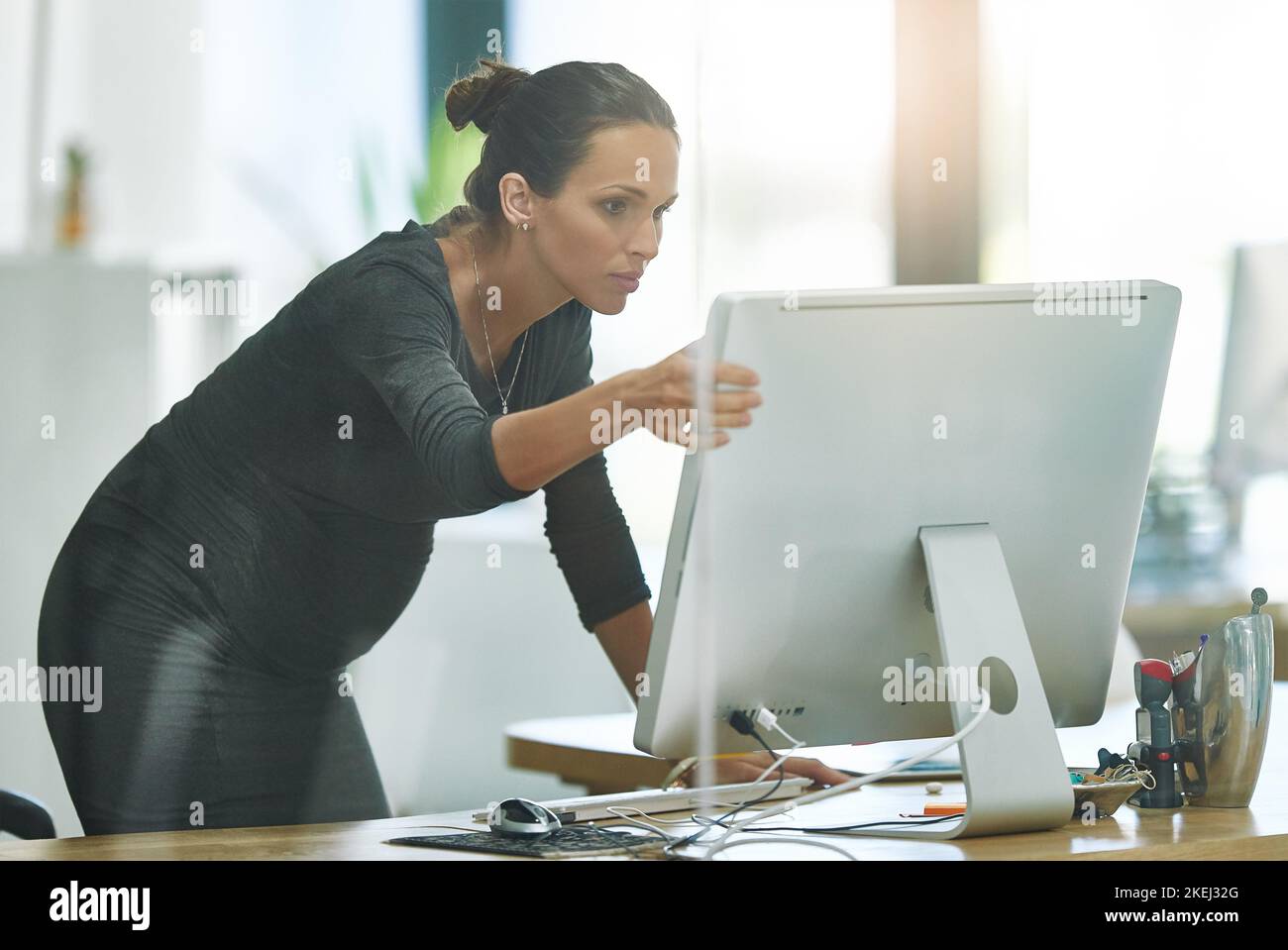 Shell have it sorted before her maternity leave. a pregnant businesswoman looking at something ...