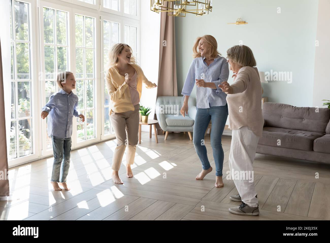 Multi-generational family dancing in sunny cozy living room Stock Photo ...