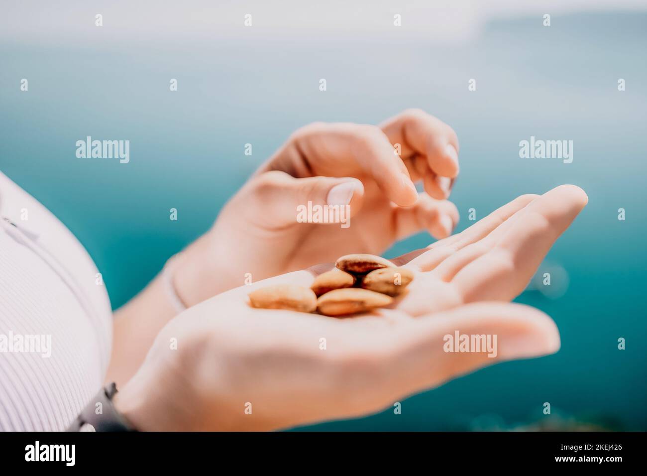 Young milky almond nuts in womans hand. A young caucasian woman Stock ...