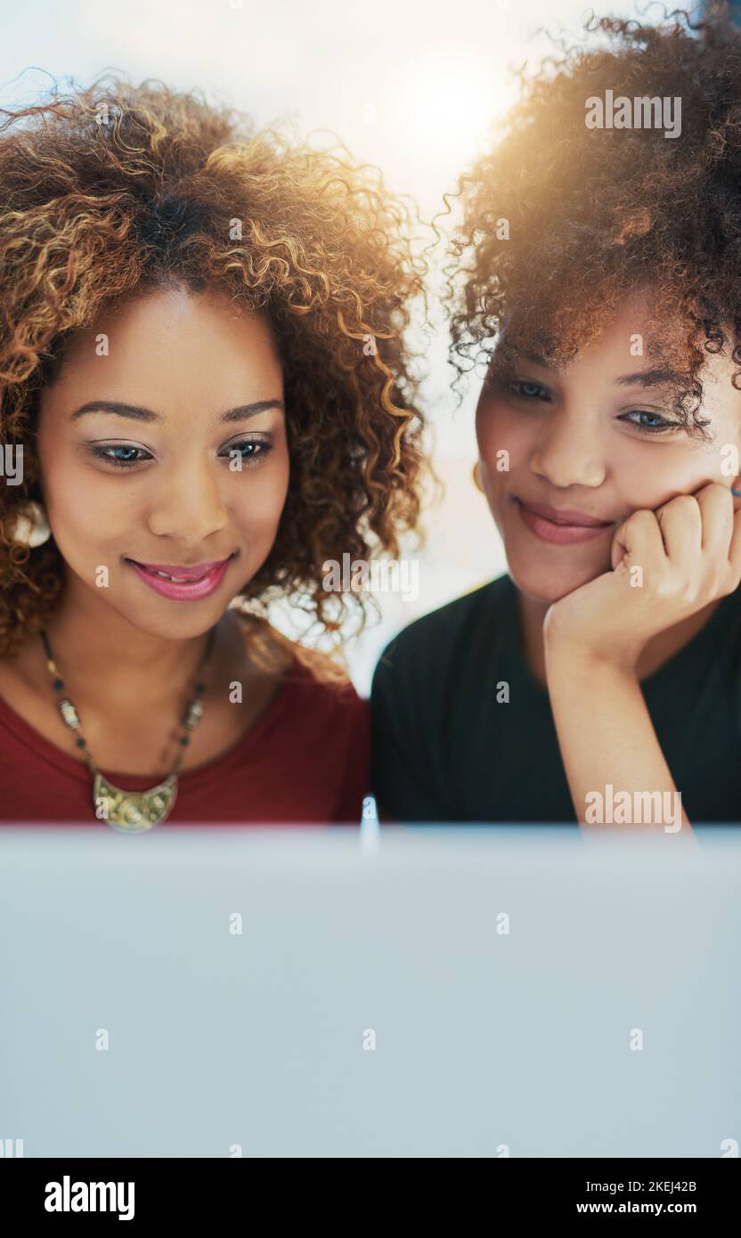 We work good together. two young designers working on a laptop together ...