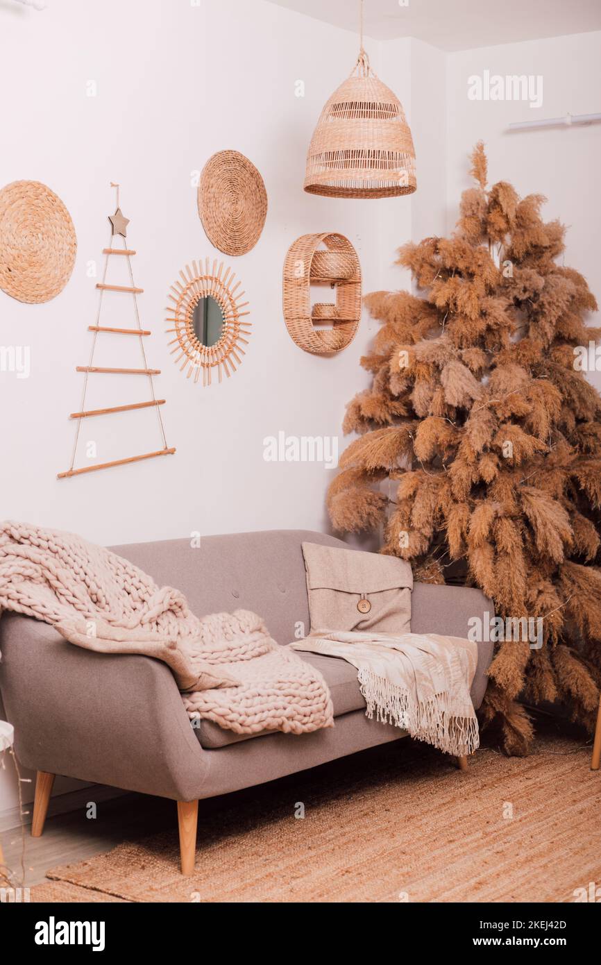 Stylish modern sofa in the home interior. Christmas tree made of dried ...