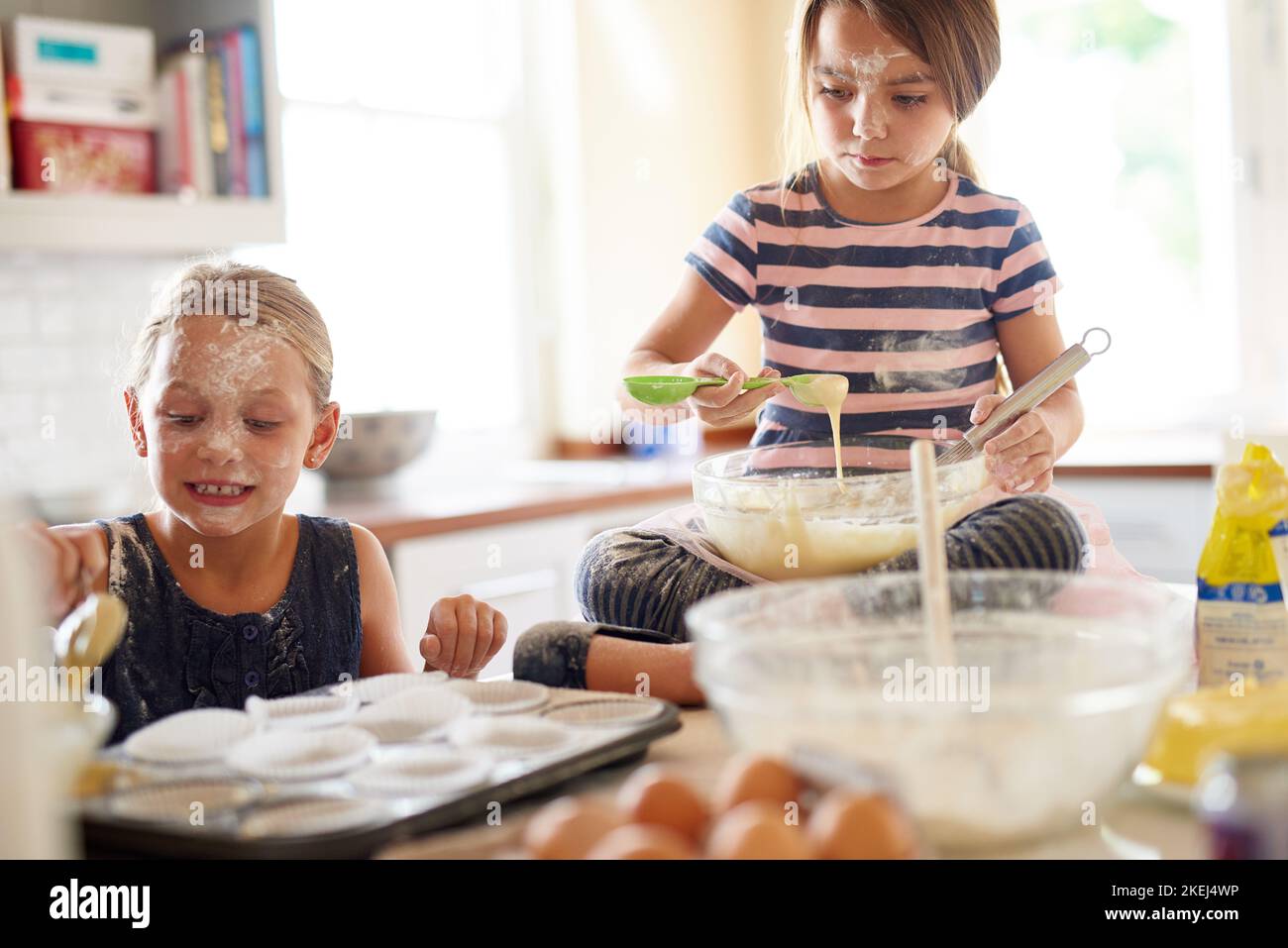 Lets get baking. two little girls baking in the kitchen Stock Photo - Alamy