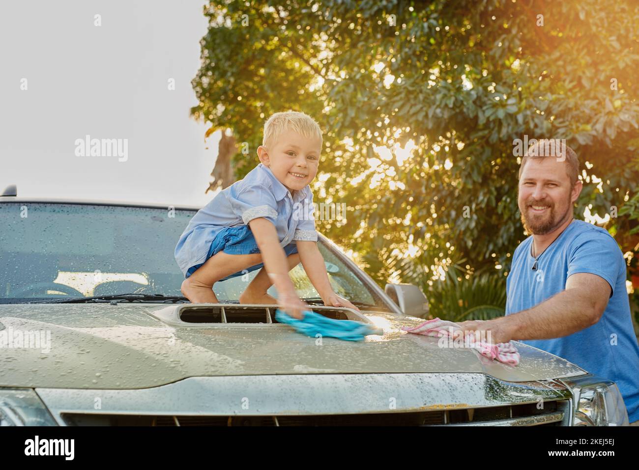 We clean as a team. Portrait of a father and son washing a car together ...