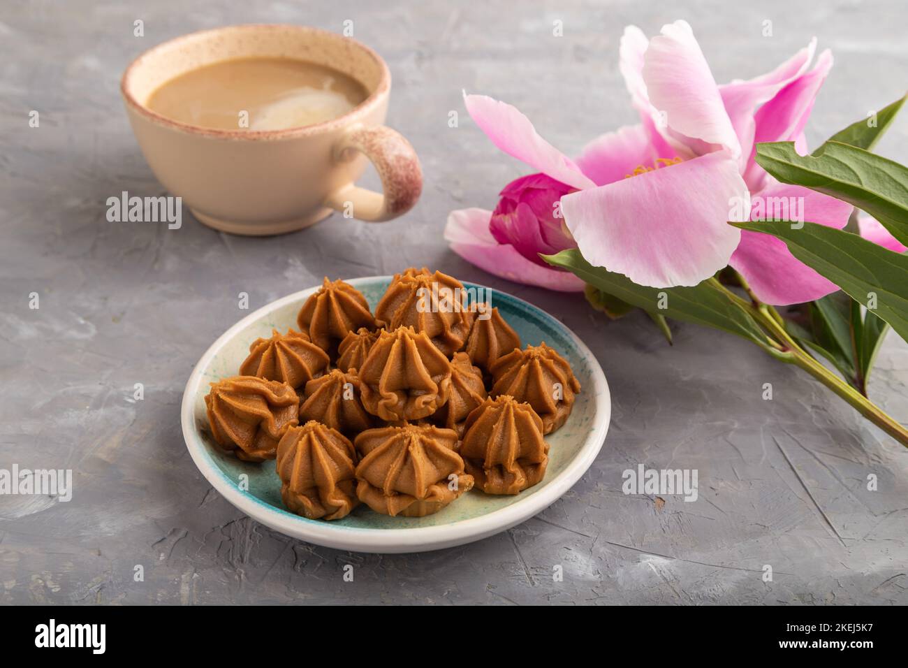Homemade soft caramel fudge candies on blue plate and cup of coffee on ...