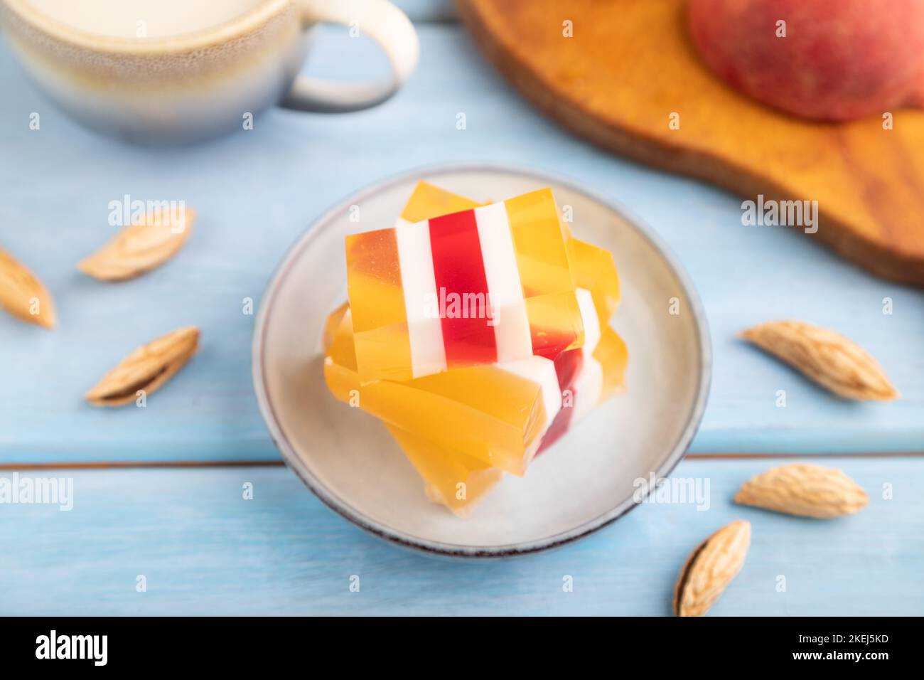 Almond milk and peach jelly on blue wooden background. side view, close ...