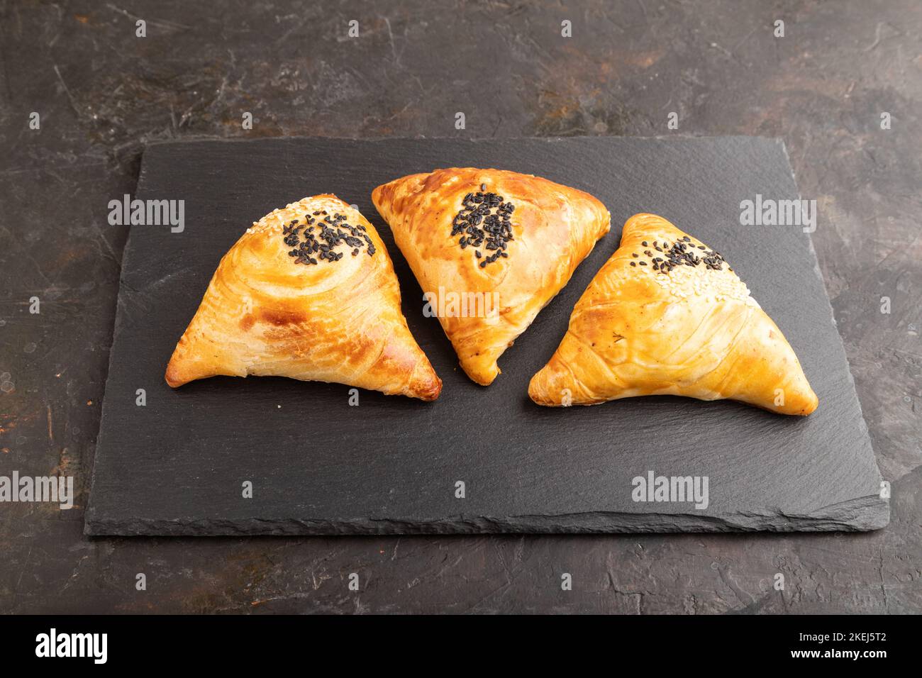 Homemade asian pastry samosa on black concrete background. side view ...