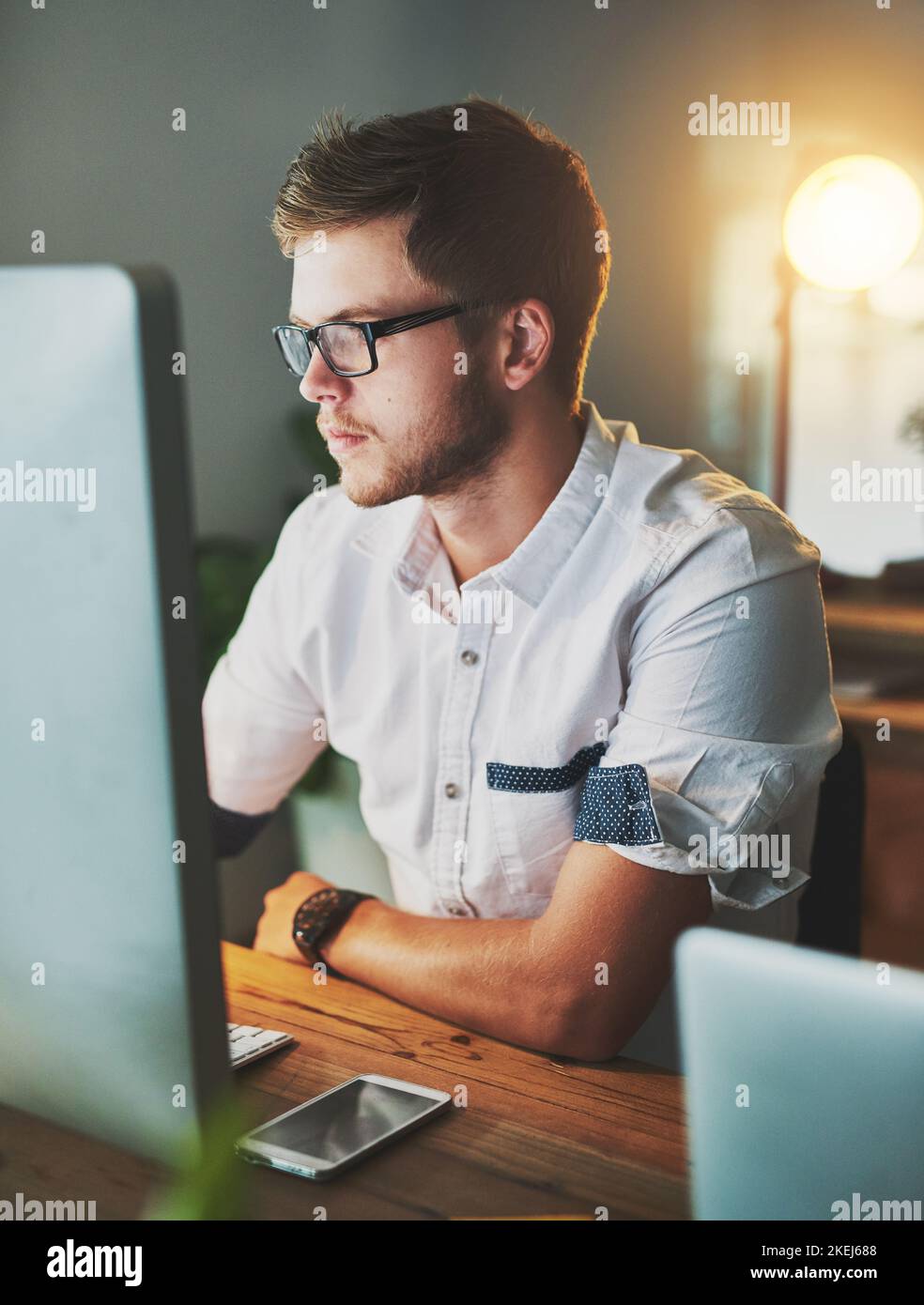 Got to keep working. a young designer working on a computer while ...