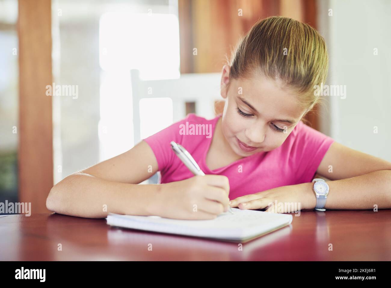 Making a note of things. Portrait of a young girl writing in a book at ...
