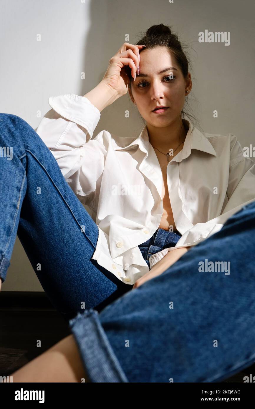 serious young woman feeling sad and scared, depressed. Sitting on white ...