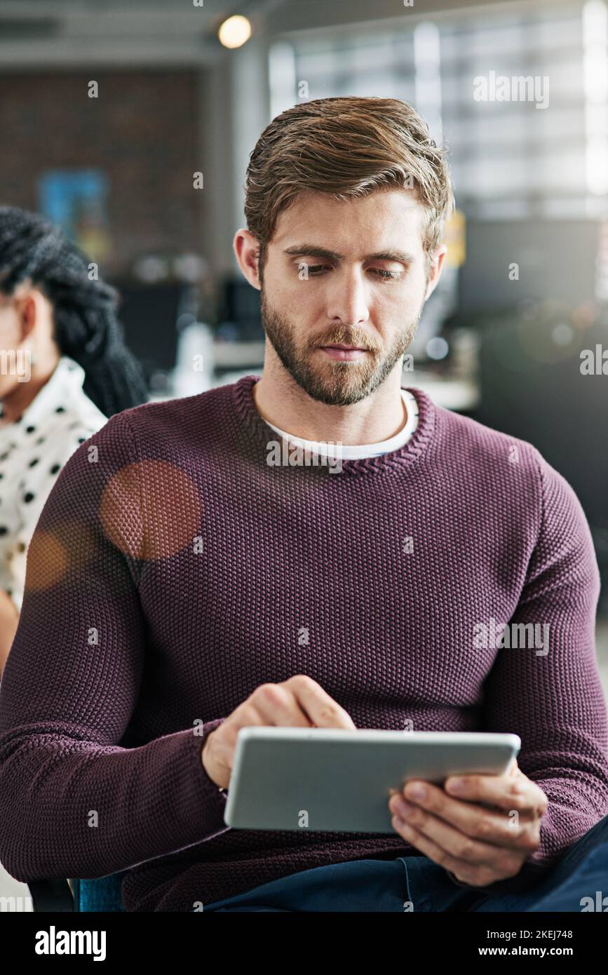 Building a brand using online tools. a young man using a digital tablet ...