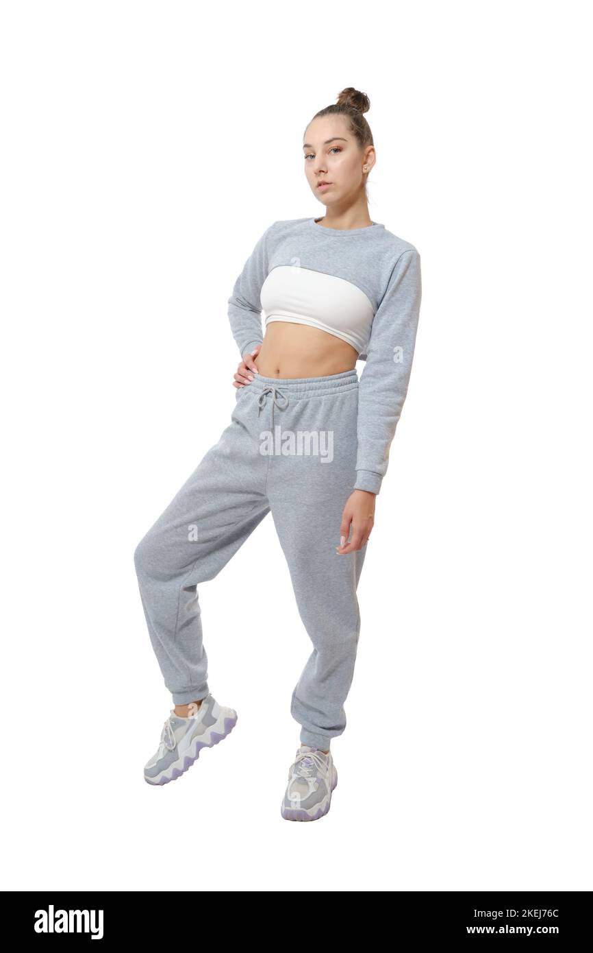Young sporty Caucasian female model in grey tracksuit isolated on white ...
