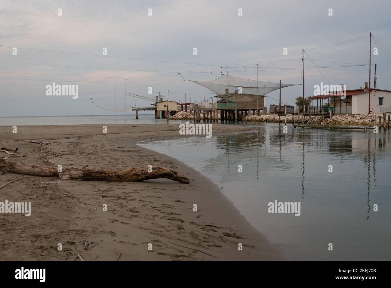 View of fishing huts on shores of estuary near Comacchio valley ...