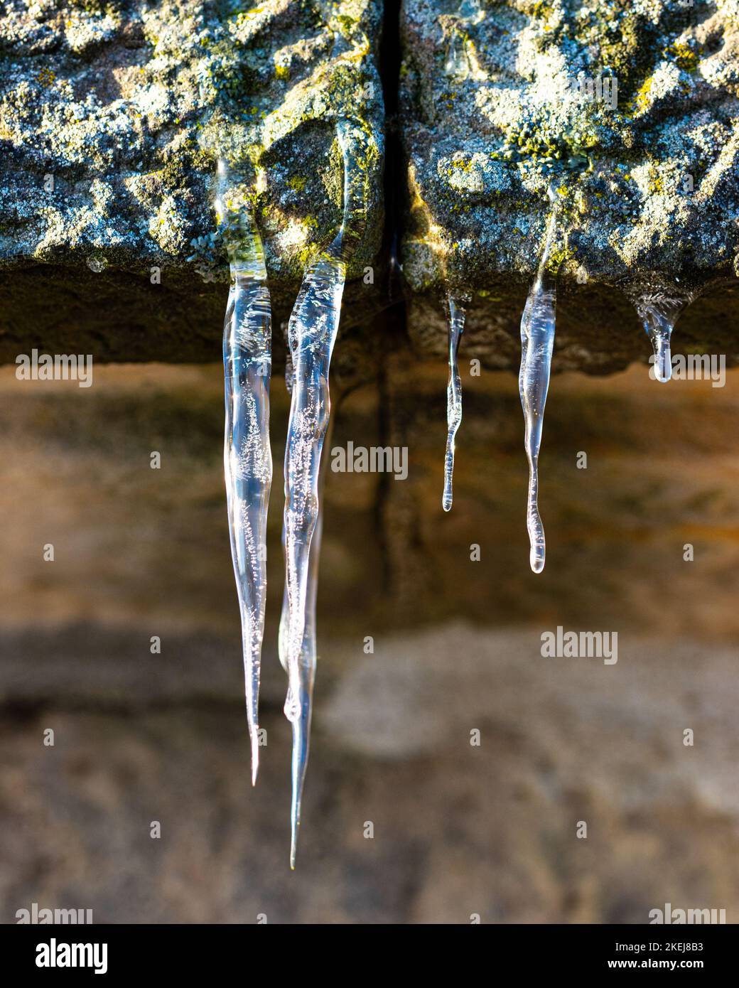 A vertical closeup of icicles hanging from a wall Stock Photo - Alamy