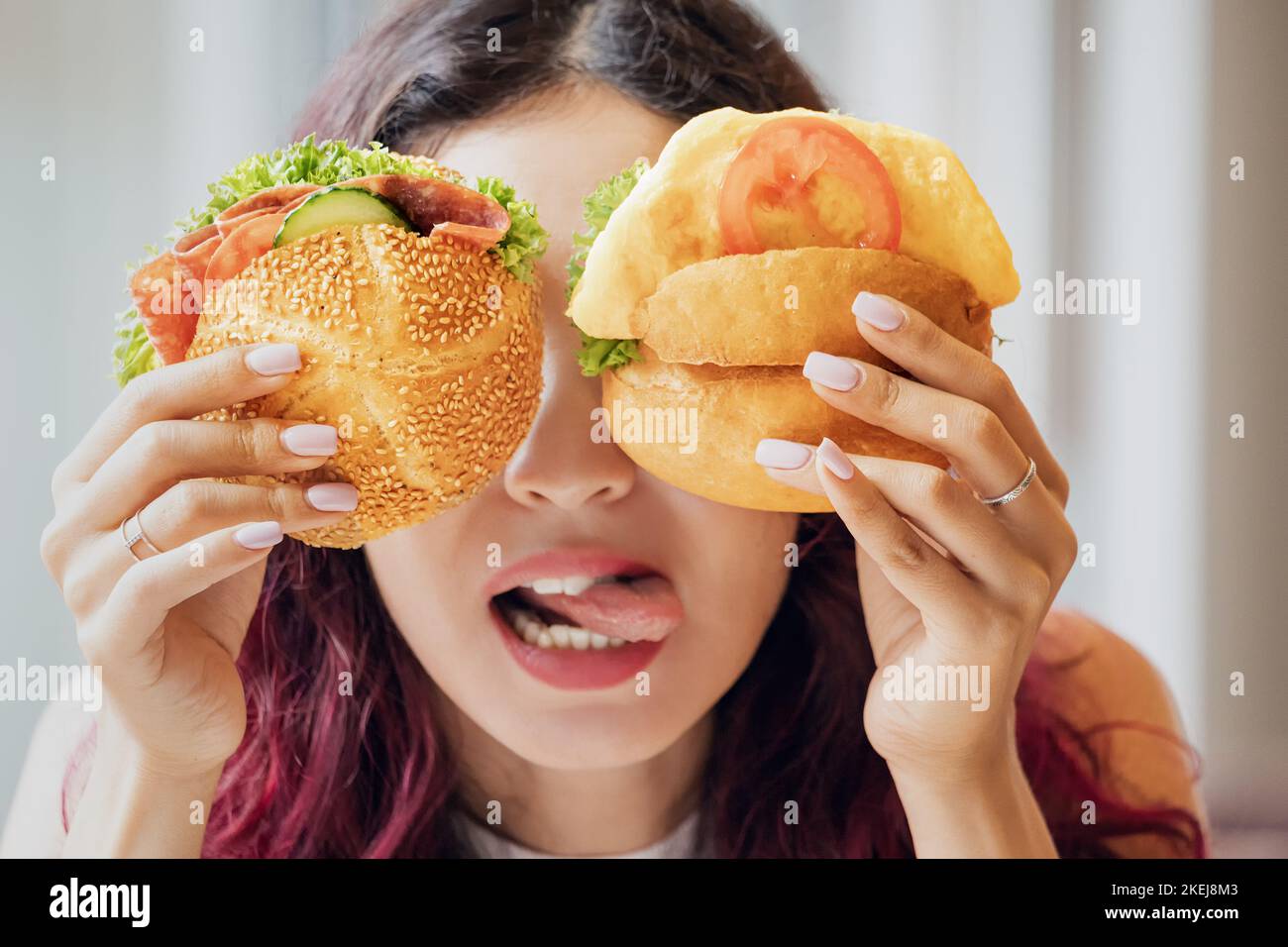 A girl in a cafe fooling around and closed her eyes with two ...