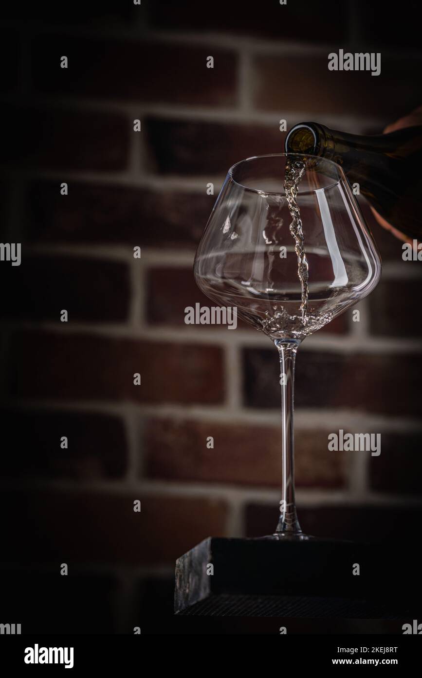 Pouring white wine Stock Photo - Alamy