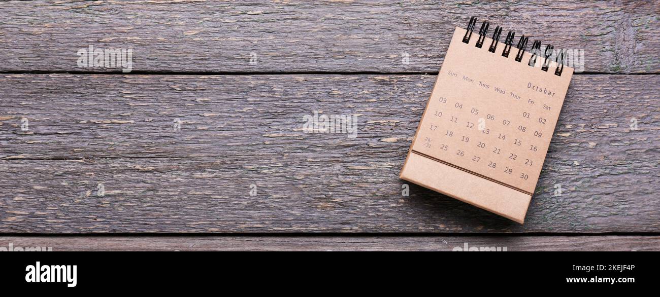 Calendar with open page of October month on wooden background with ...
