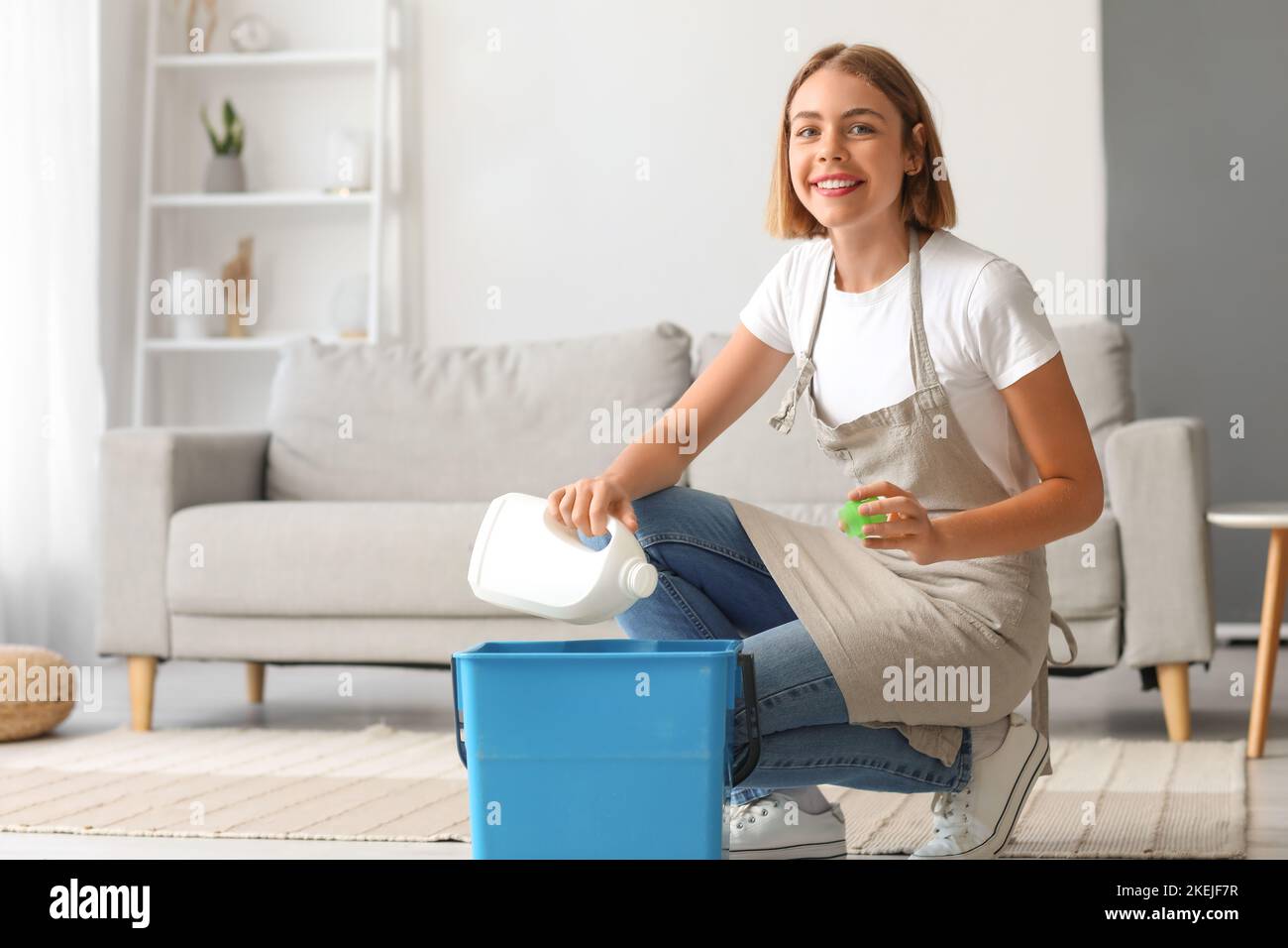 Young housewife pouring detergent into bucket at home Stock Photo - Alamy