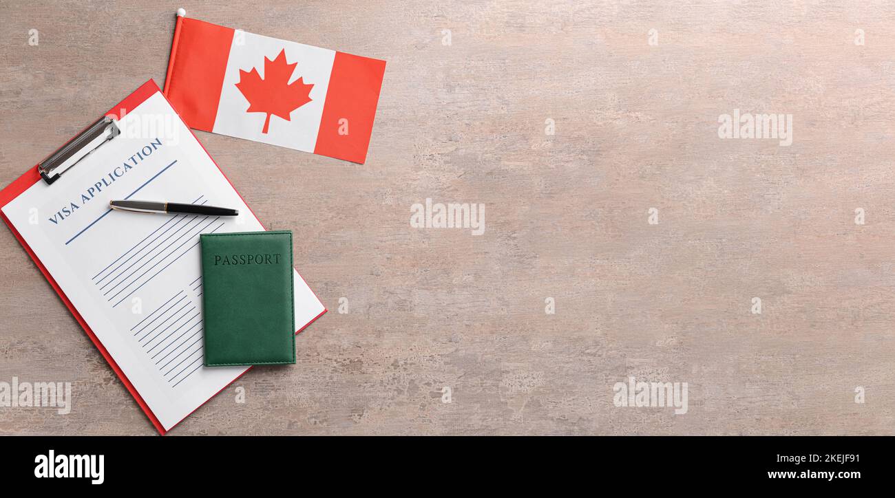 Banner with visa application form, passport and Canadian flag on table ...
