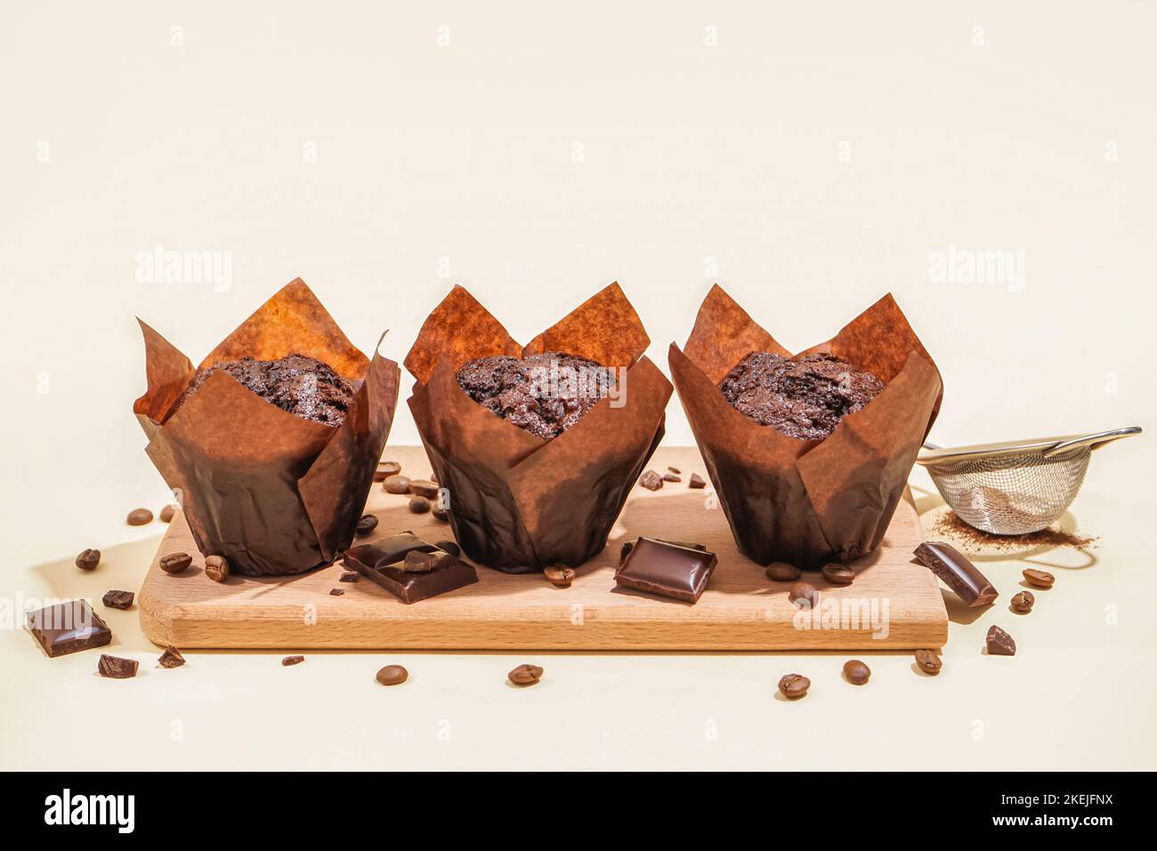 Wooden board with tasty chocolate muffins on color background Stock ...