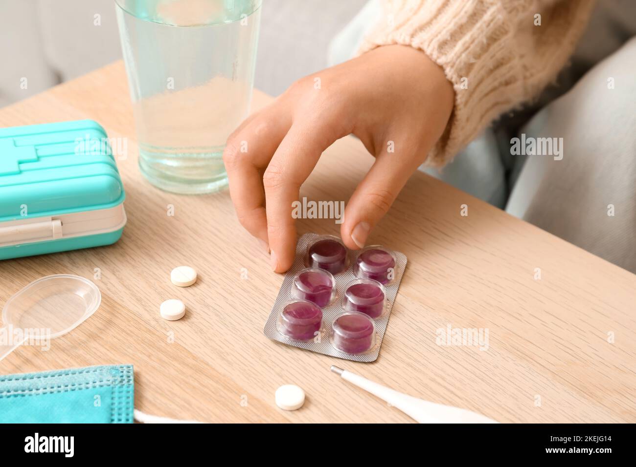 Woman taking pills for sore throat at home, closeup Stock Photo - Alamy