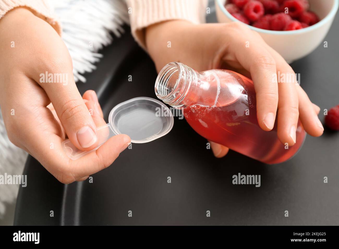 Woman pouring syrup for sore throat into spoon at home, closeup Stock ...
