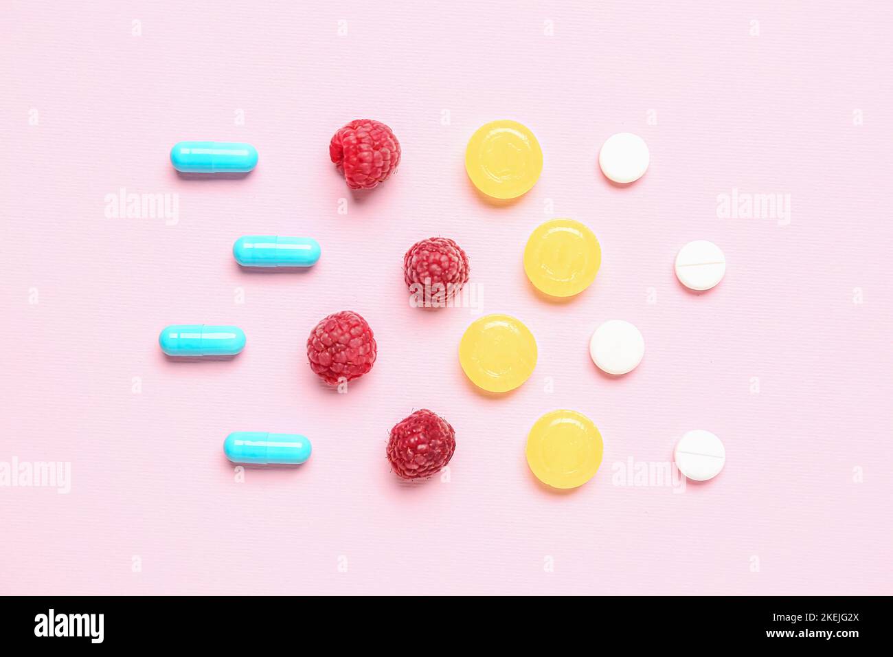 Pills for sore throat and raspberries on pink background Stock Photo ...