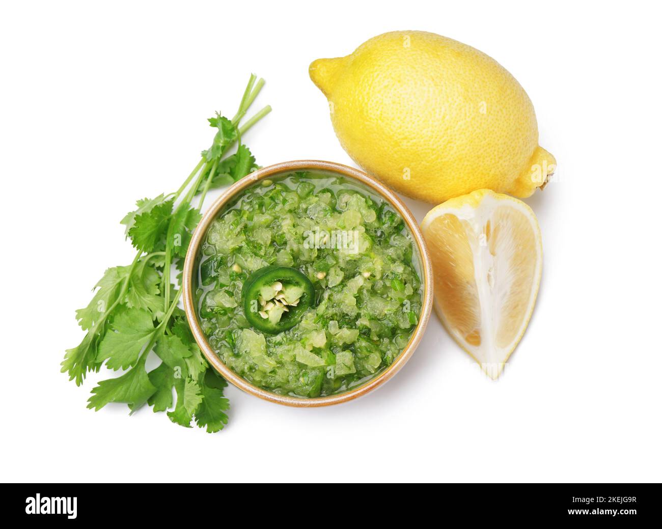 Bowl of green salsa sauce and lemon on white background Stock Photo - Alamy