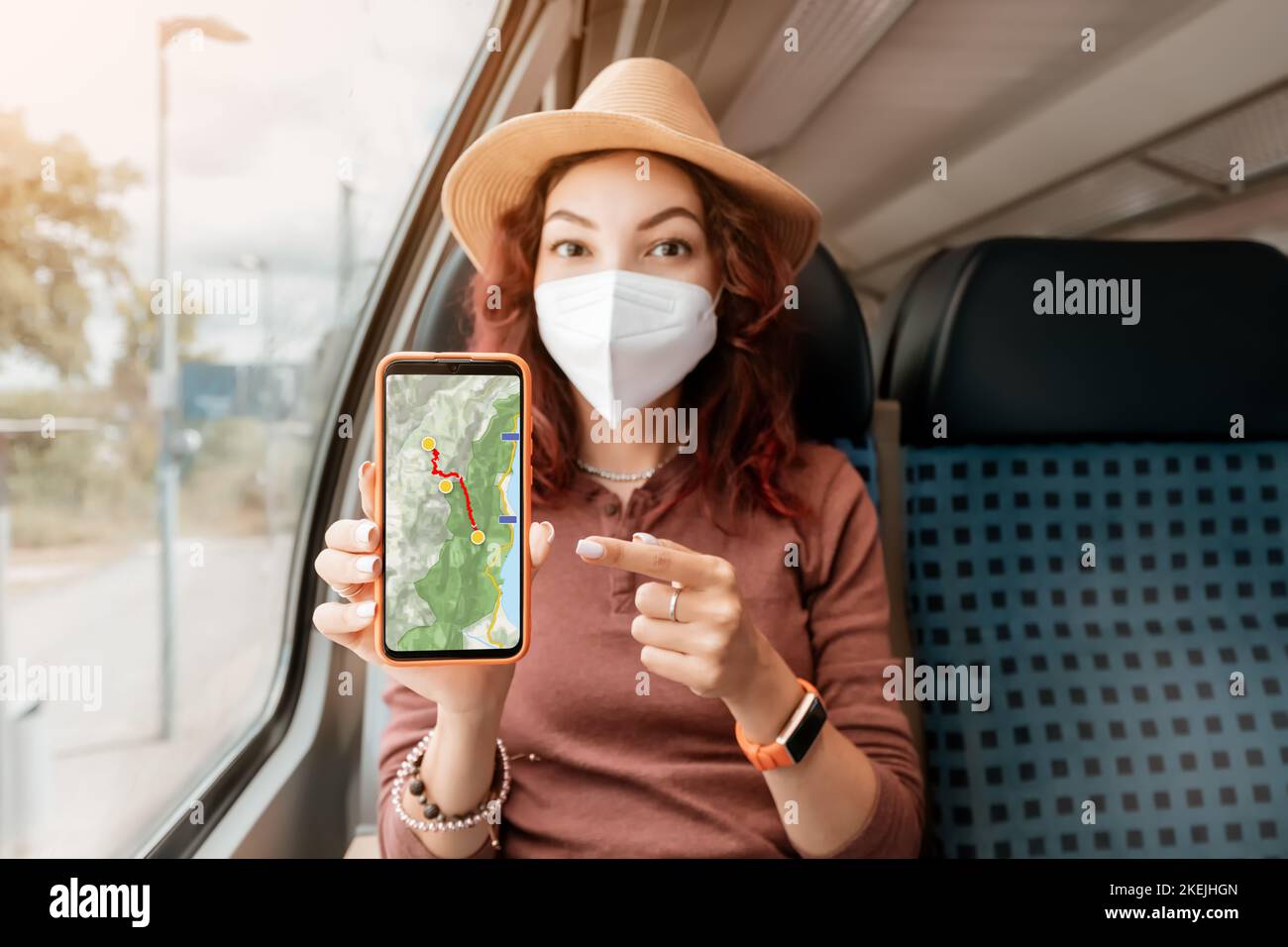 A girl in a protective medical mask rides a speed intercity train and ...