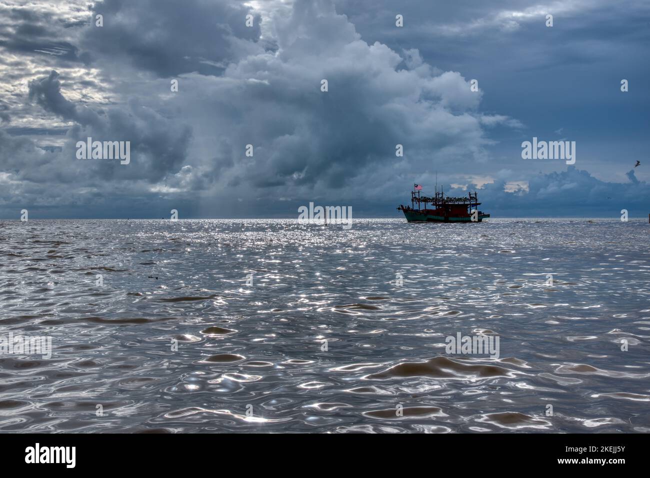 distance view of fishing boat sailing at the horizon Stock Photo - Alamy