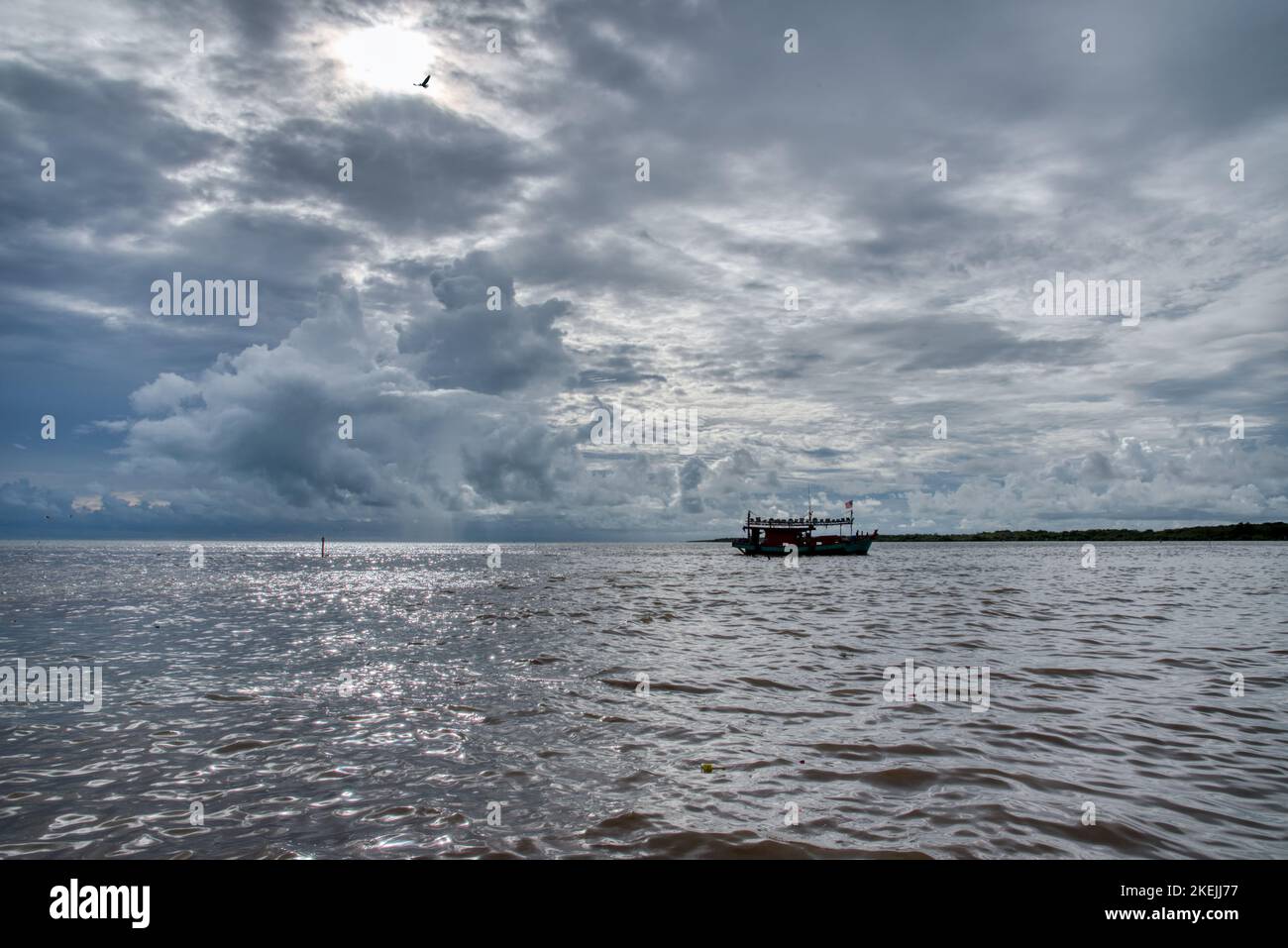 distance view of fishing boat sailing at the horizon Stock Photo - Alamy