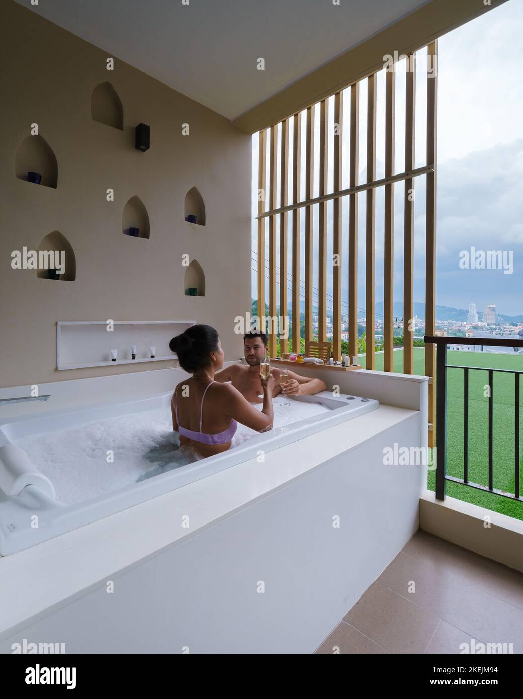 couple drinking champagne in a jacuzzi during honeymoon vacation, Asian ...