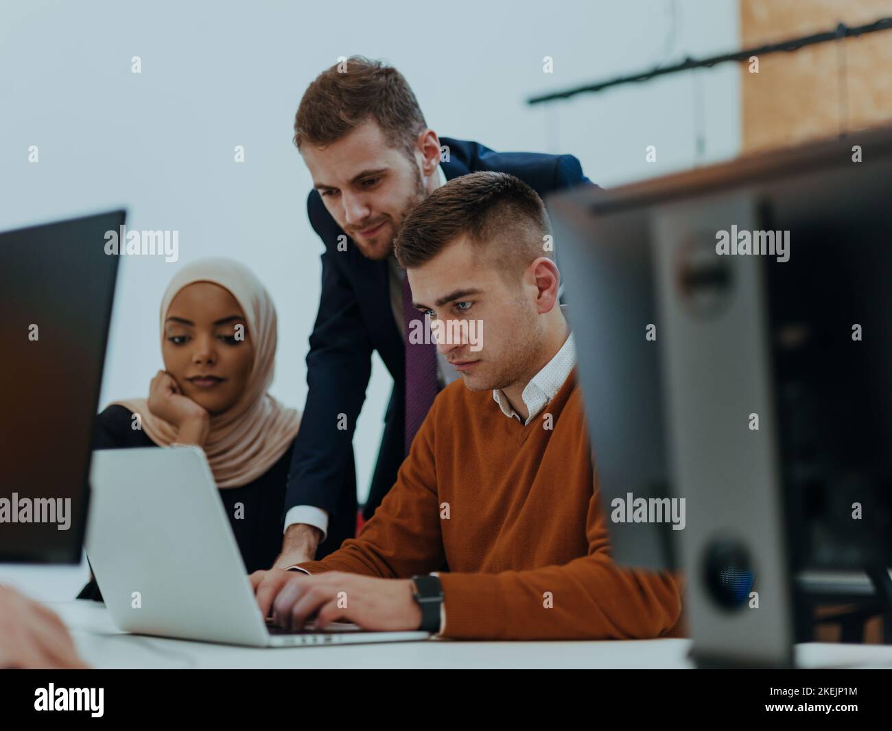 Group of multi-ethnic colleagues working on desktop computers, laptop ...