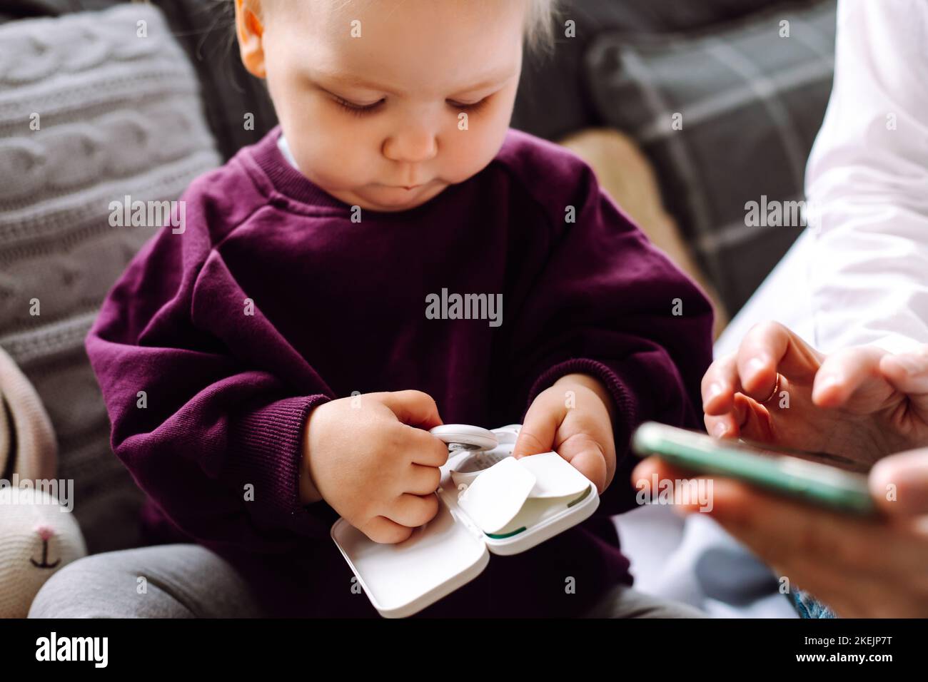 Portrait of little girl holding box with digital thermometer measuring ...