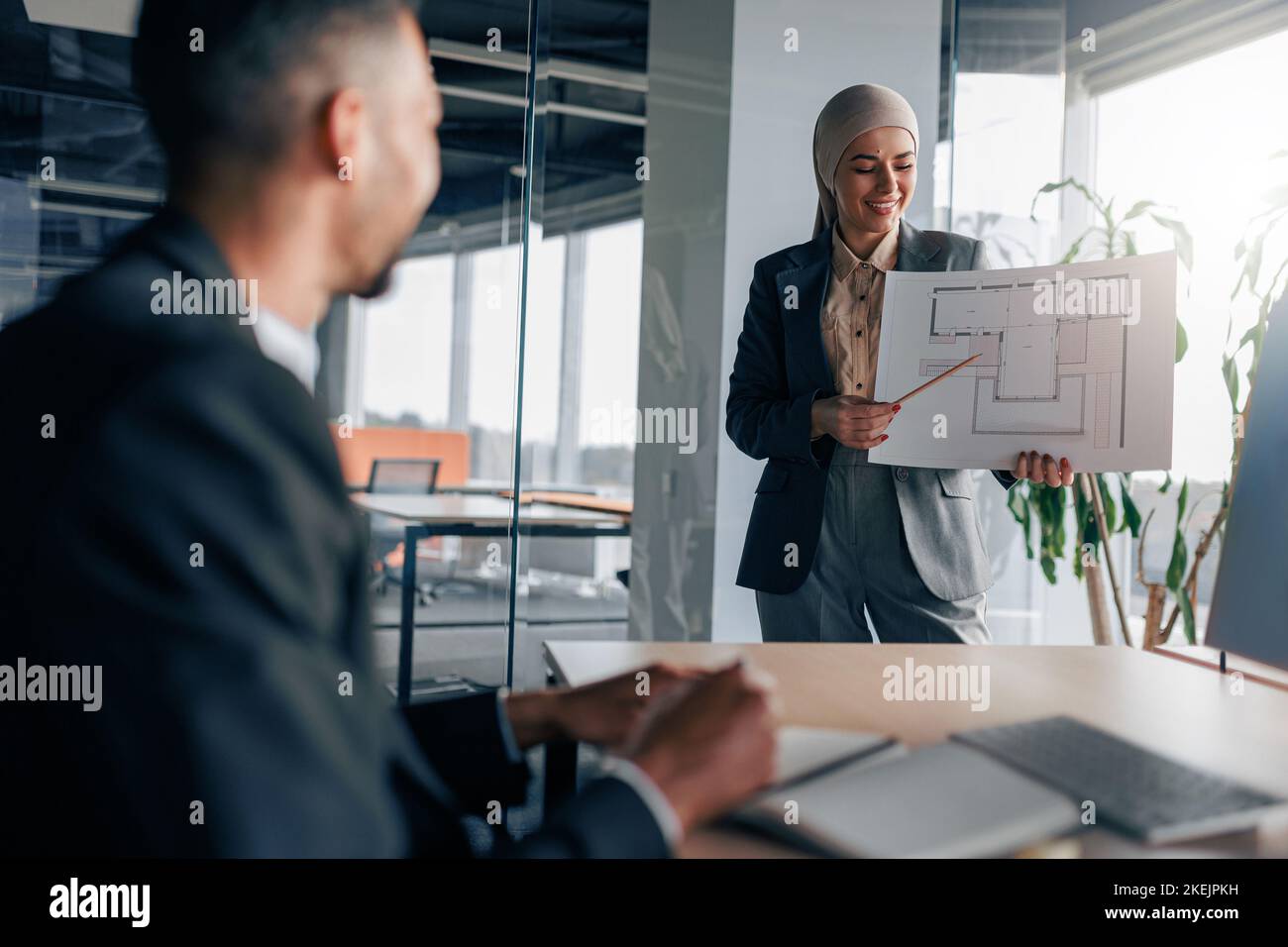 Muslim business woman during meeting showing her project to colleagues ...