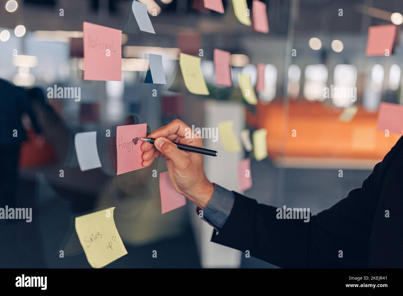 Businesswoman hand's is writing on sticky notes on motivation board in ...