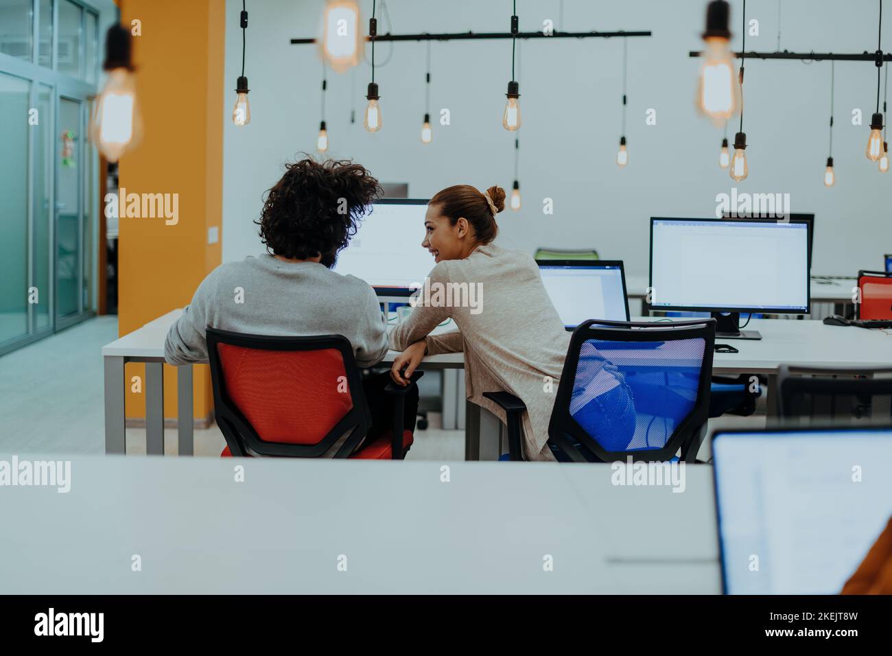 Two colleagues working on a project in modern startup offices. Guy with ...