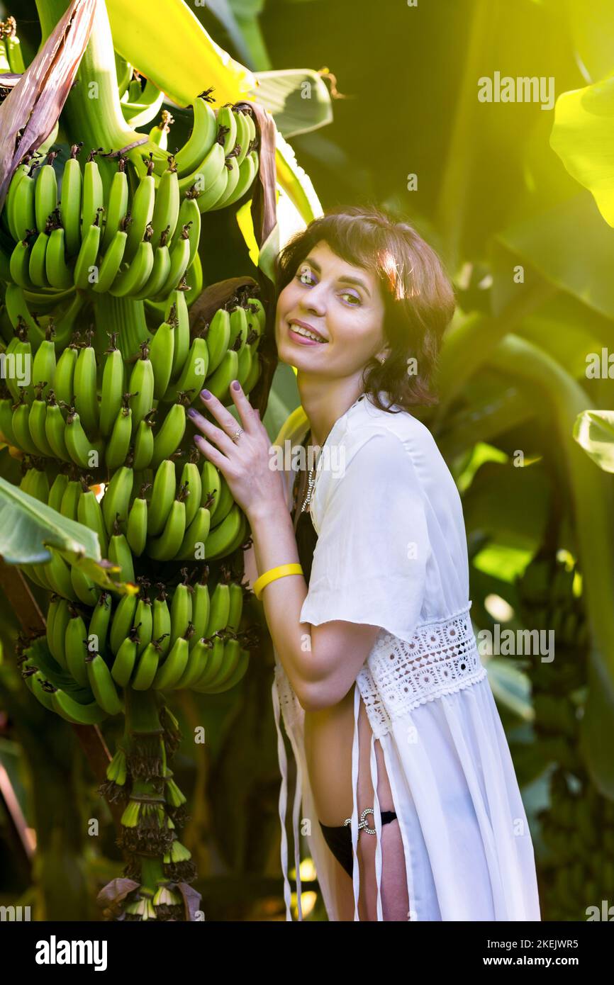 Young woman hugging a branch with bananas tropical garden Stock Photo ...