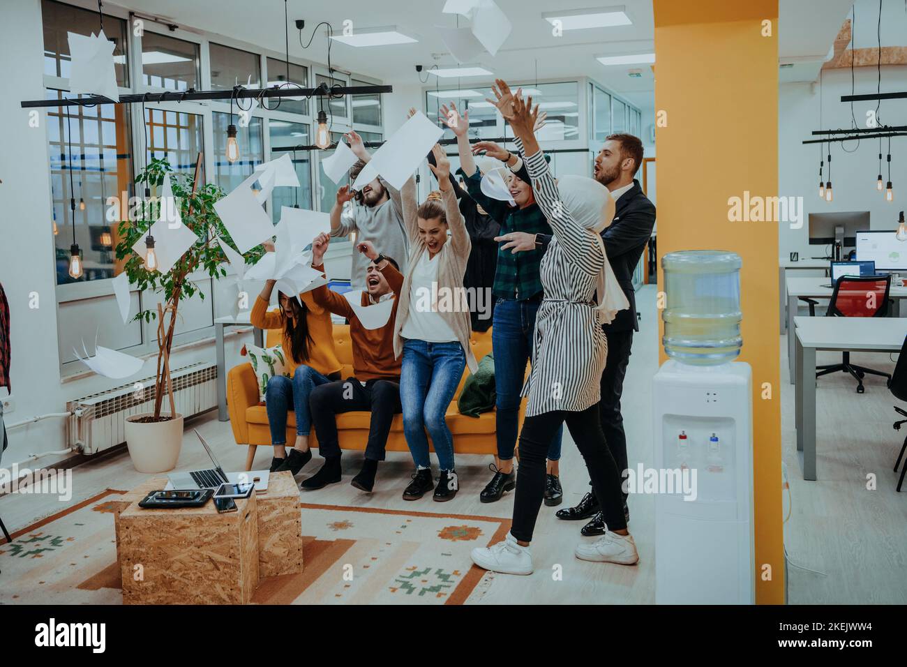 Group of business people throwing paper in air at modern startup office ...