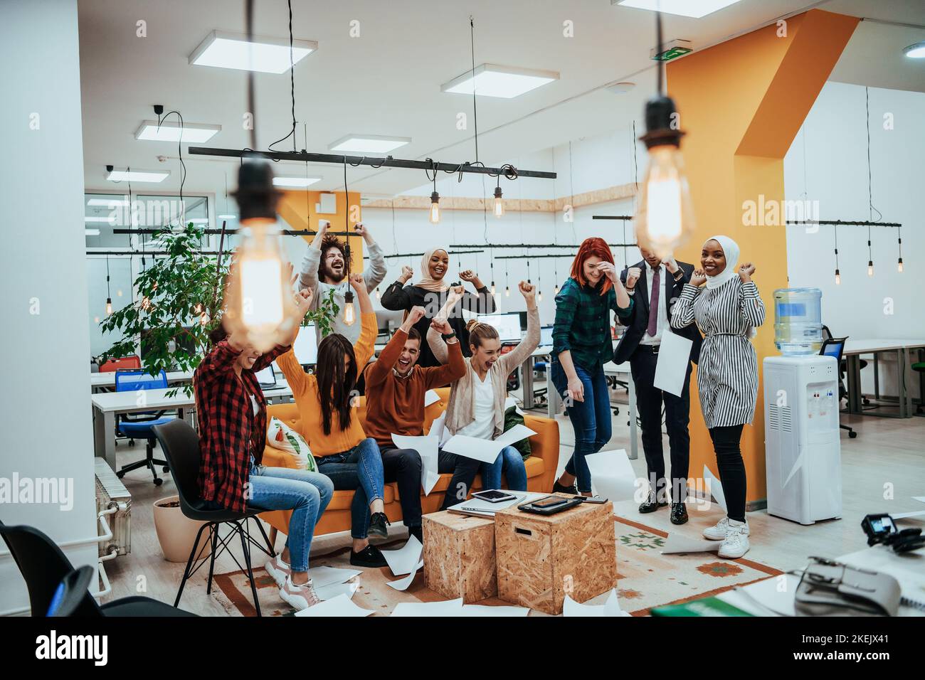 Group of business people throwing paper in air at modern startup office ...